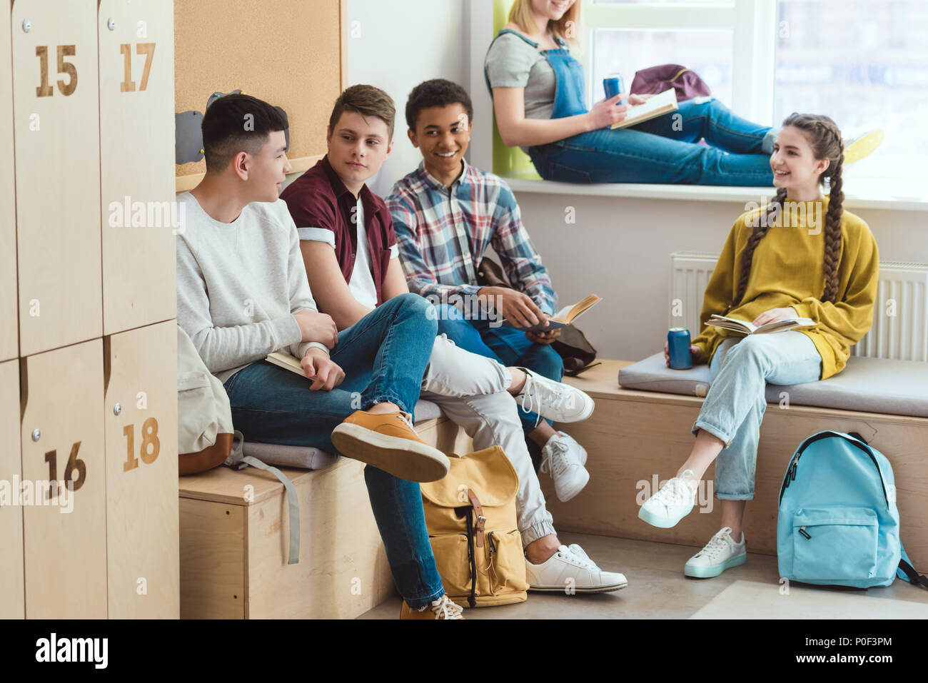 Multicultural smiling schoolchildren having fun during school break ...