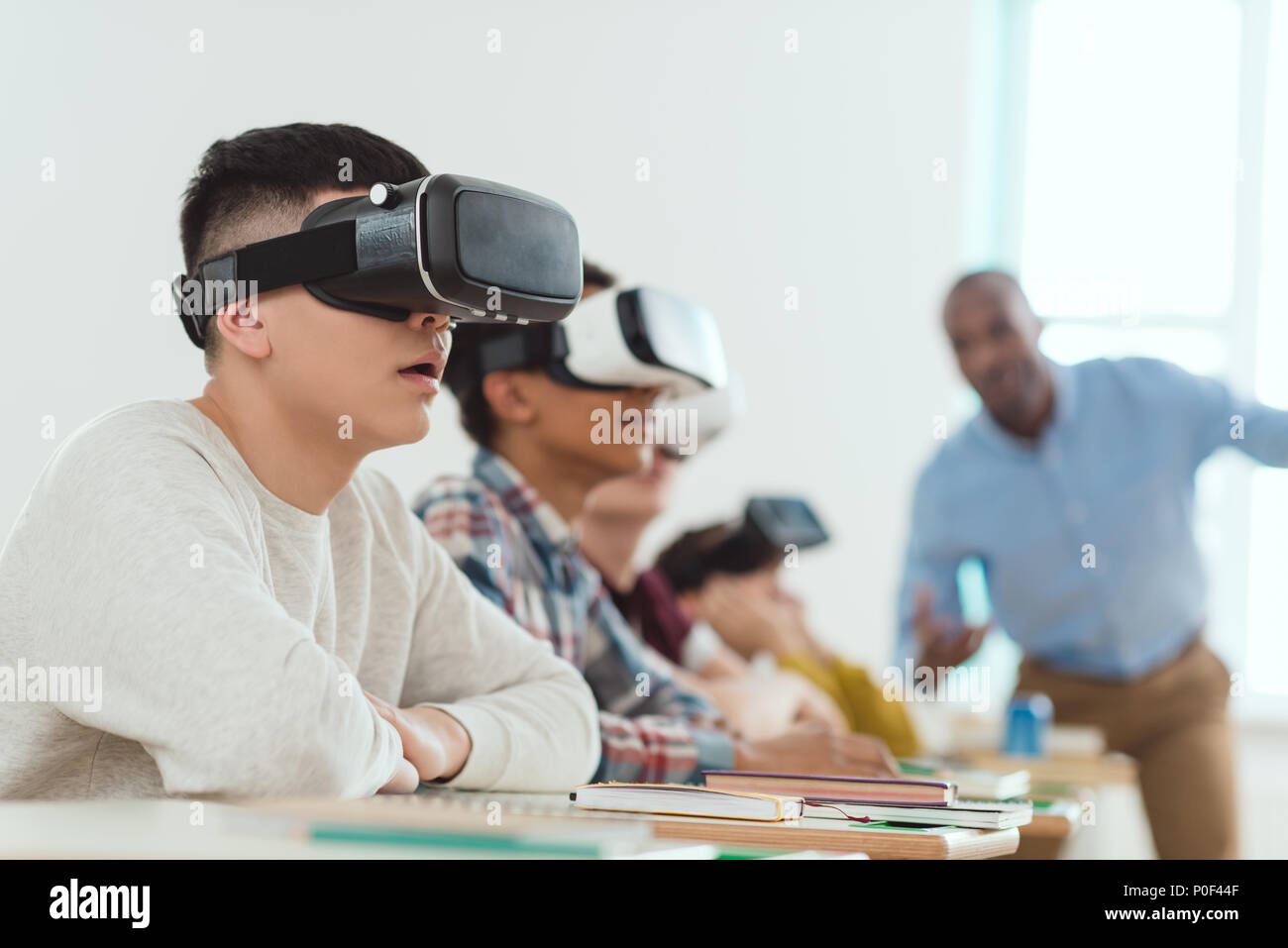Side view of multicultural schoolchildren using virtual reality ...