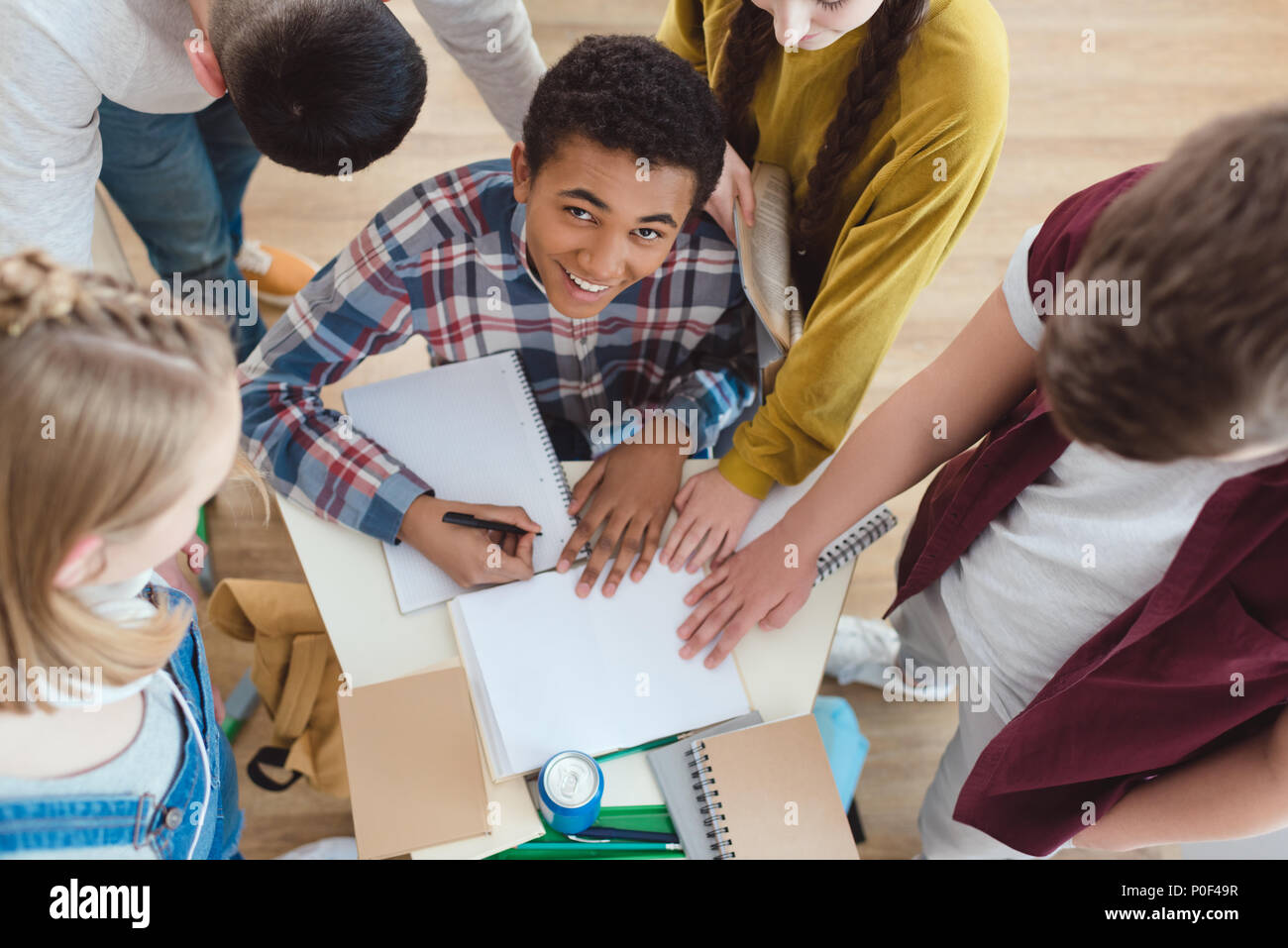 high angle view of high school students helping their classmate with ...