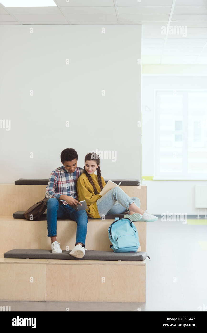 high school students couple doing homework at school corridor together ...