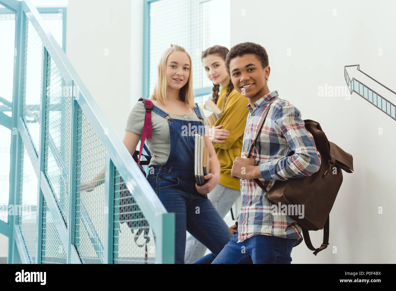 high school students standing on stairs at school and looking at camera ...