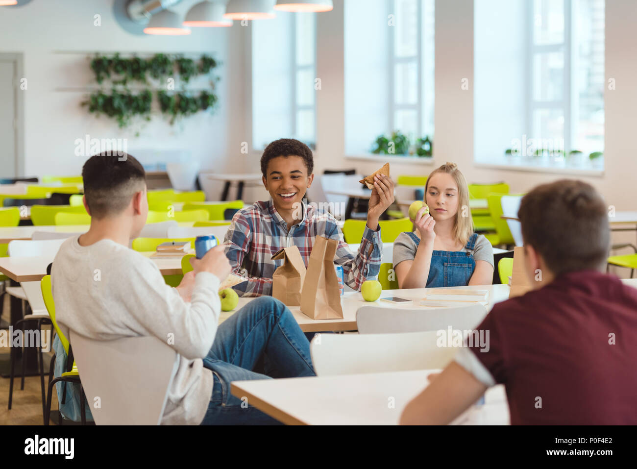 happy multiethnic group of high school students chatting while taking ...