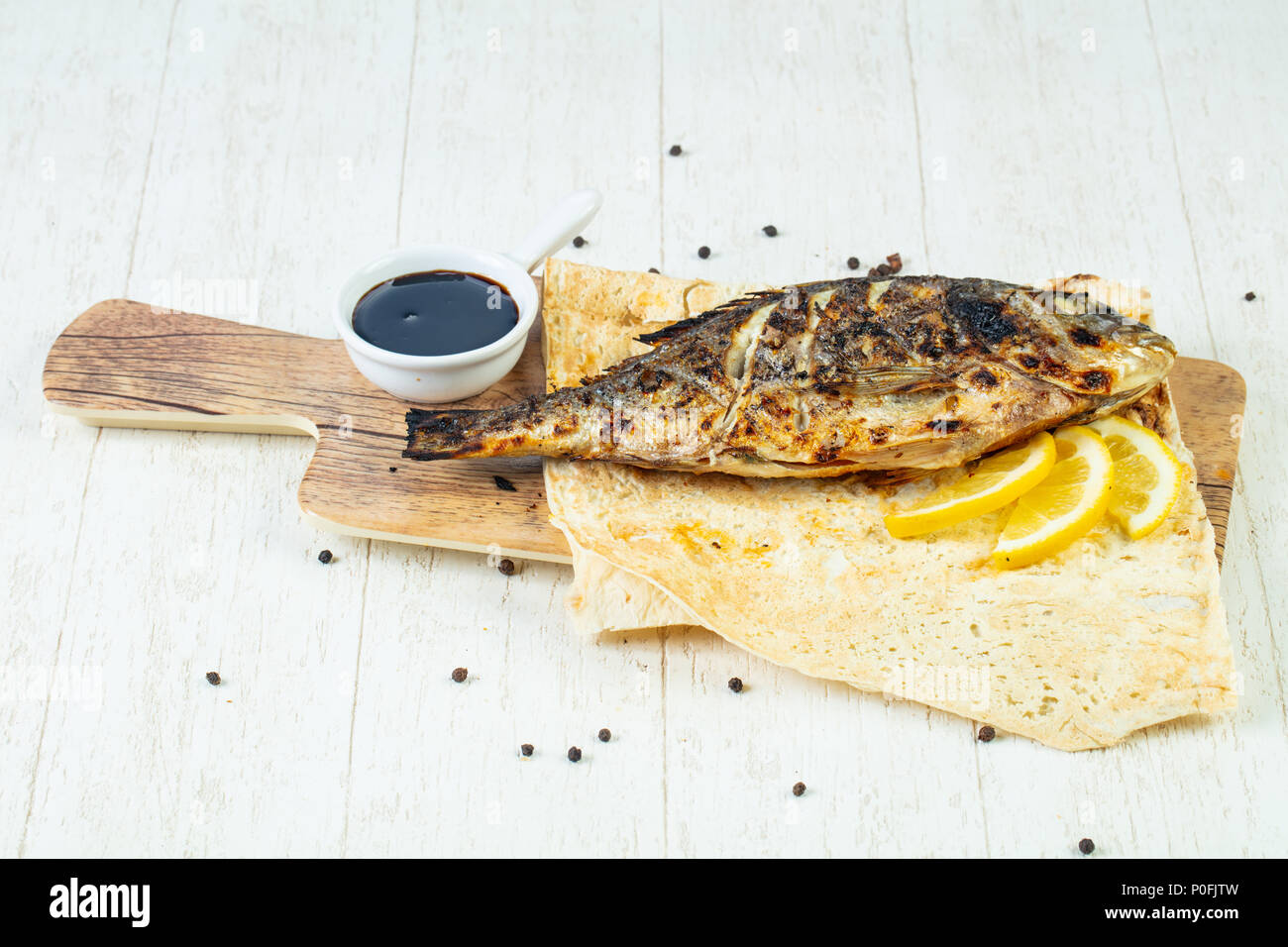 Grilled dorada with lemon and sauce Stock Photo - Alamy