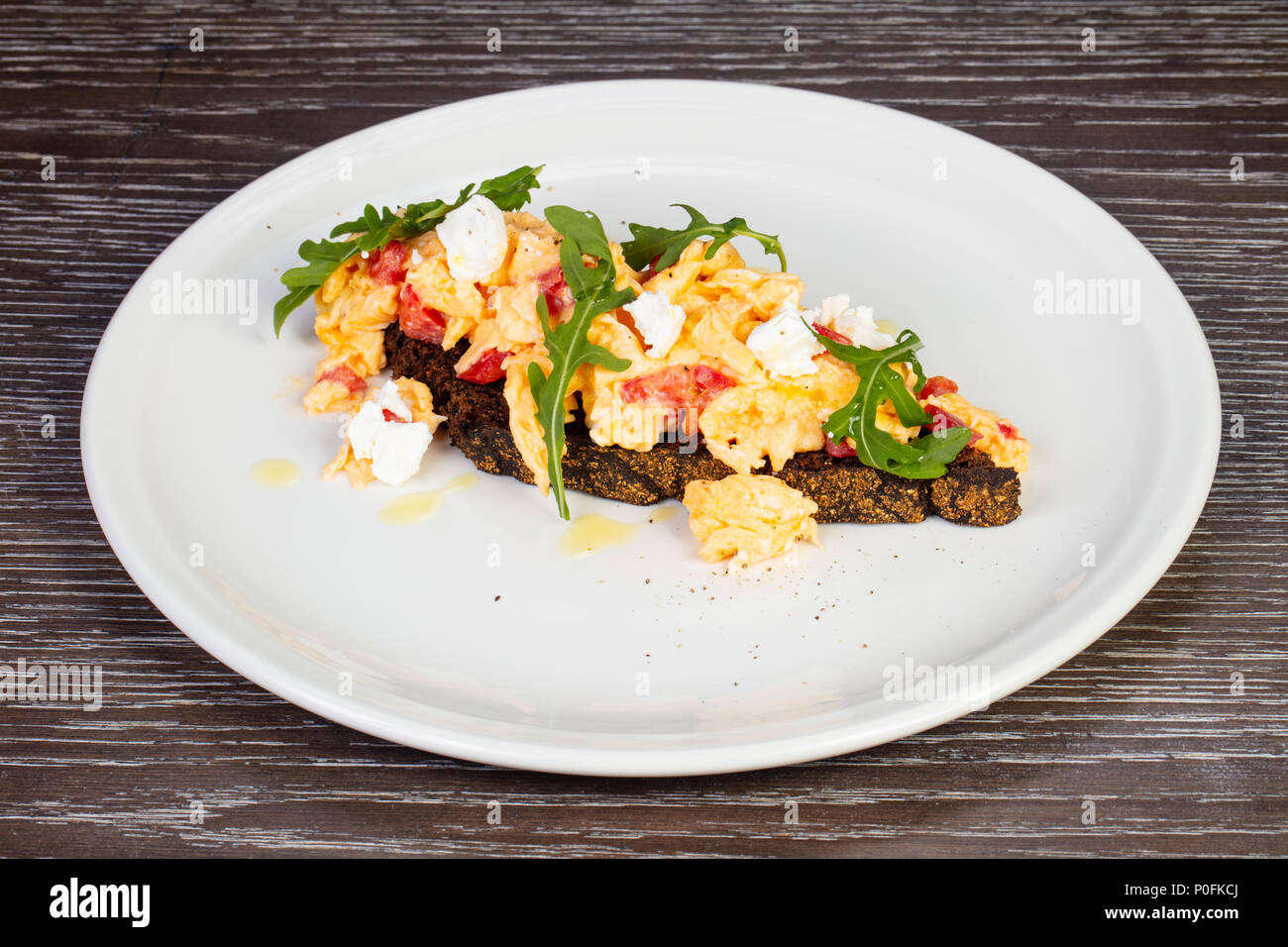 Tasty scramble on bread with egg, cheese and tomatoes Stock Photo - Alamy