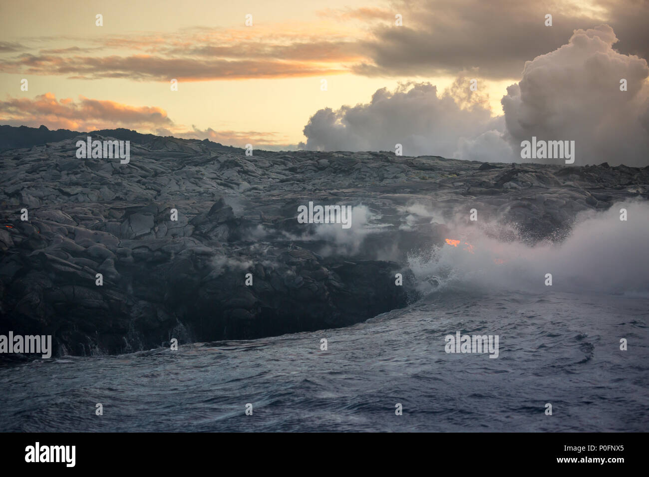 Sunrise over the Hawaiian coast as lava flows into the ocean Stock ...