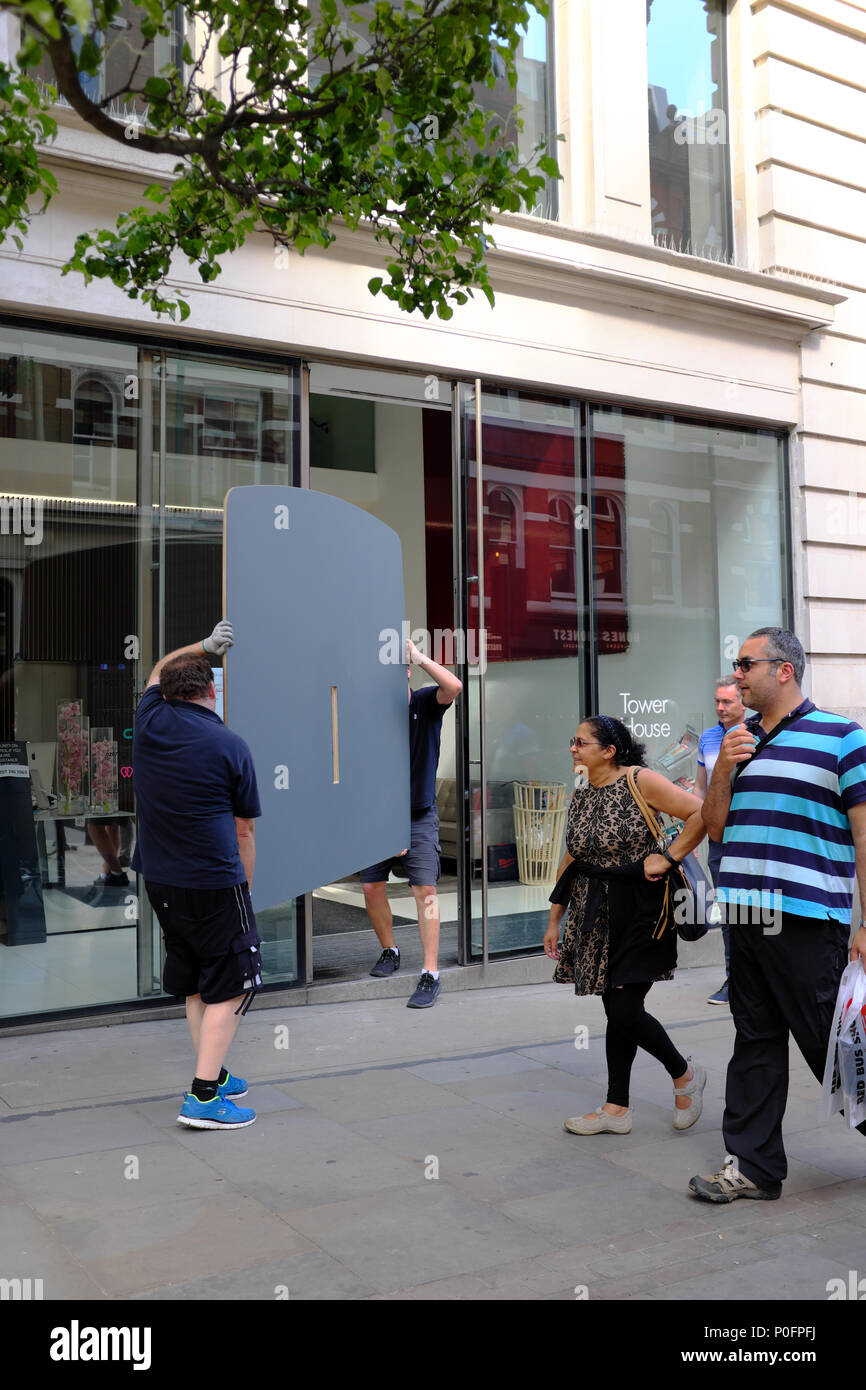 Men carrying large board into shop, Covent Garden, London, England, UK ...