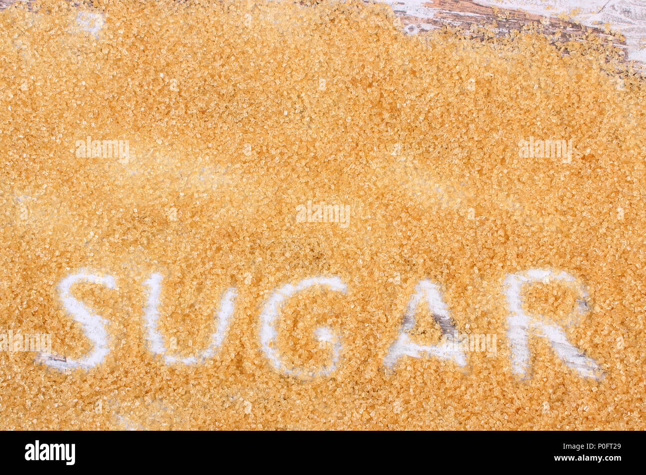 Word sugar written in granulated natural brown cane sugar, copy space ...