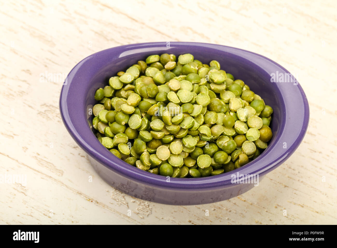 Green peas pile in the bowl over wooden background Stock Photo - Alamy