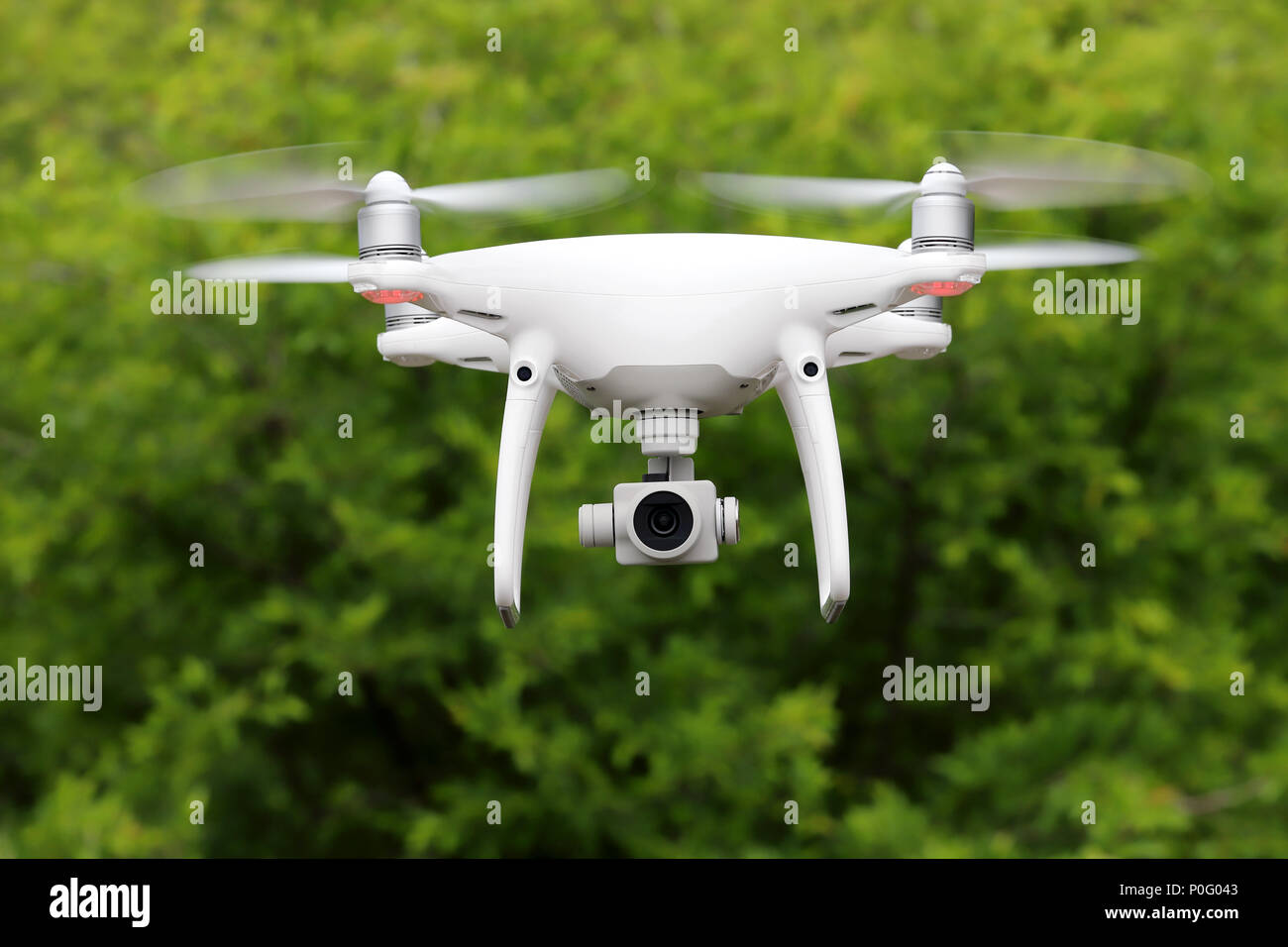 White remote controlled drone flying in the forest, in air Stock Photo ...
