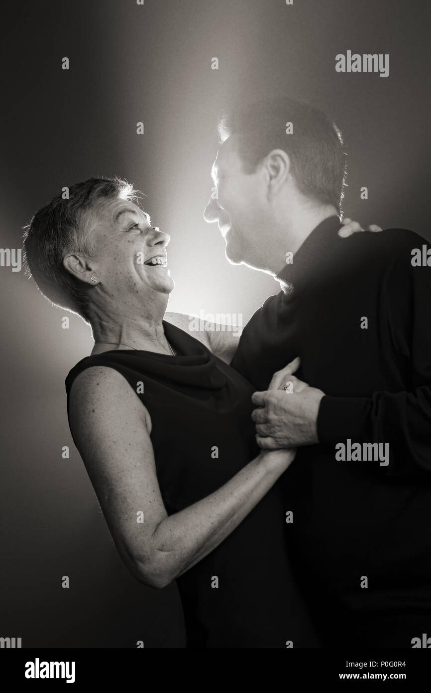 Studio portrait of senior couple dancing, face to face, holding hands ...