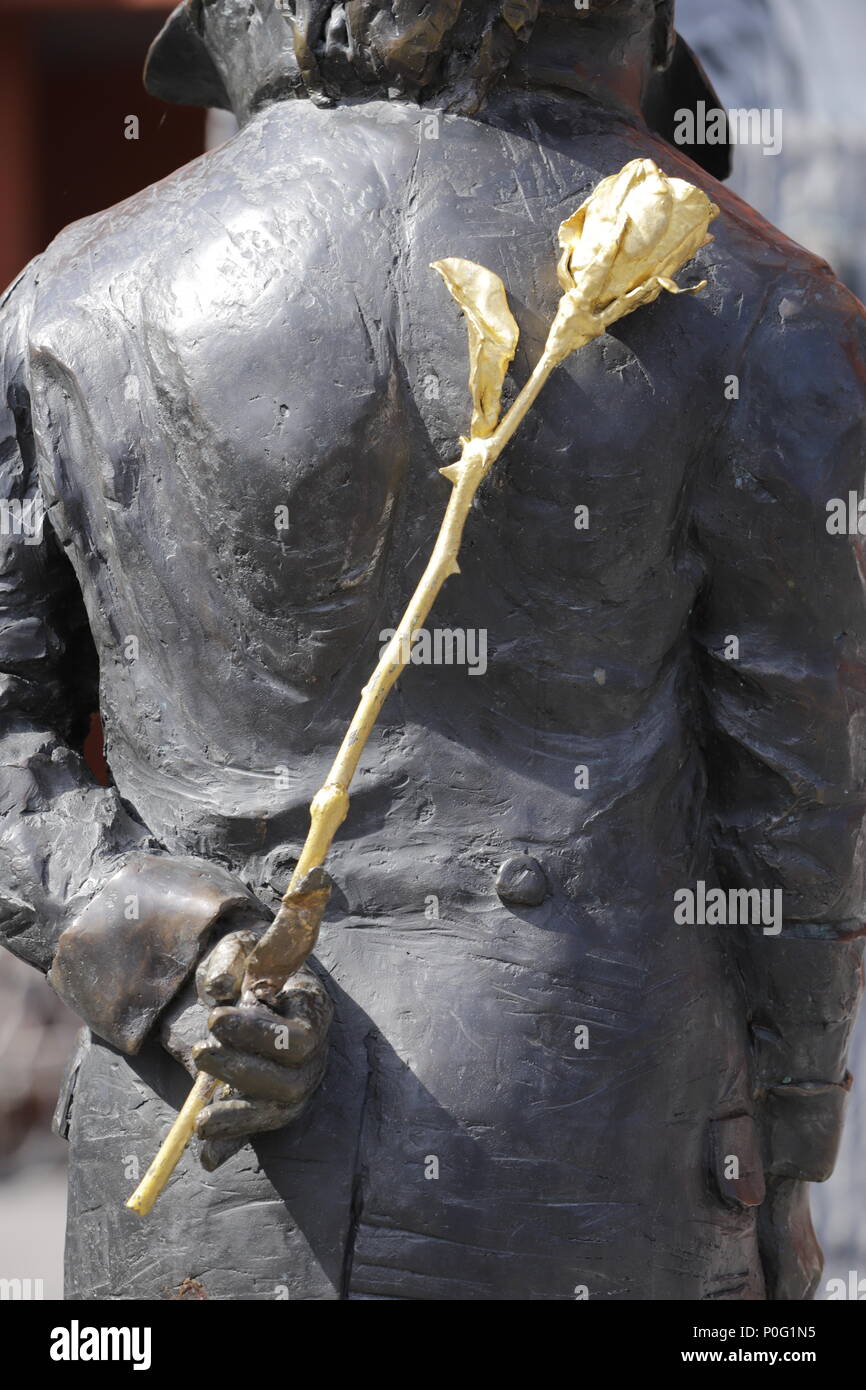 Statue to keep a golden rose behind your back Stock Photo - Alamy
