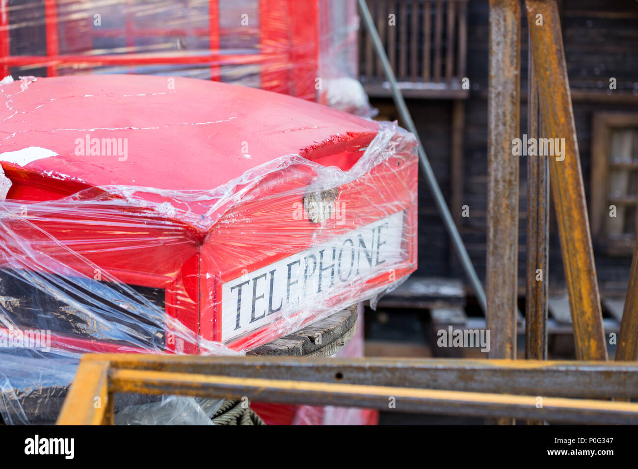 Old shabby replica of London Red telephone box. Rusty metal structures ...