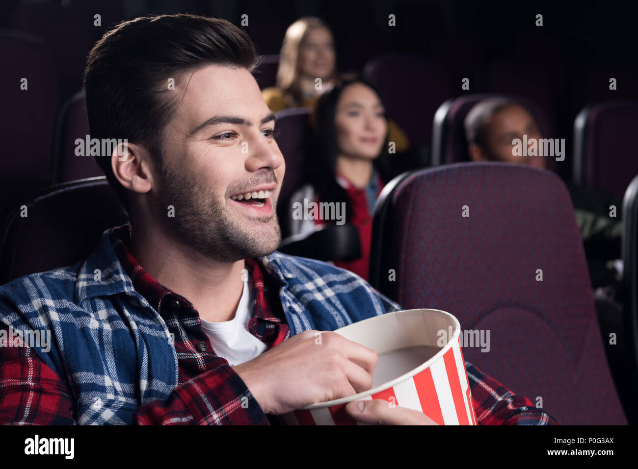 smiling handsome man with popcorn watching movie in cinema Stock Photo ...