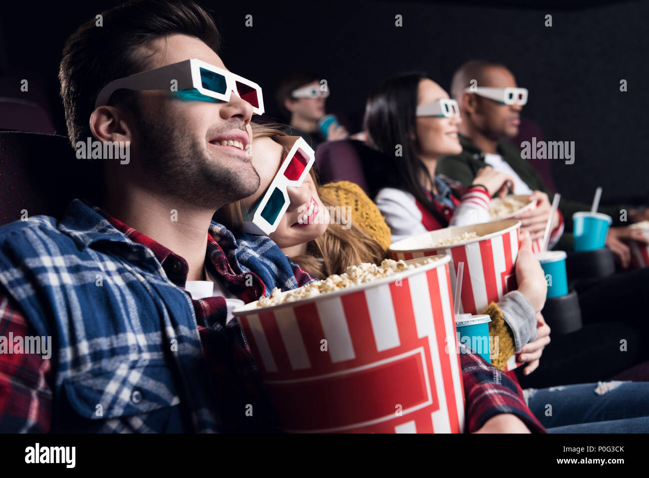 young couples in 3d glasses with popcorn and soda watching movie in ...