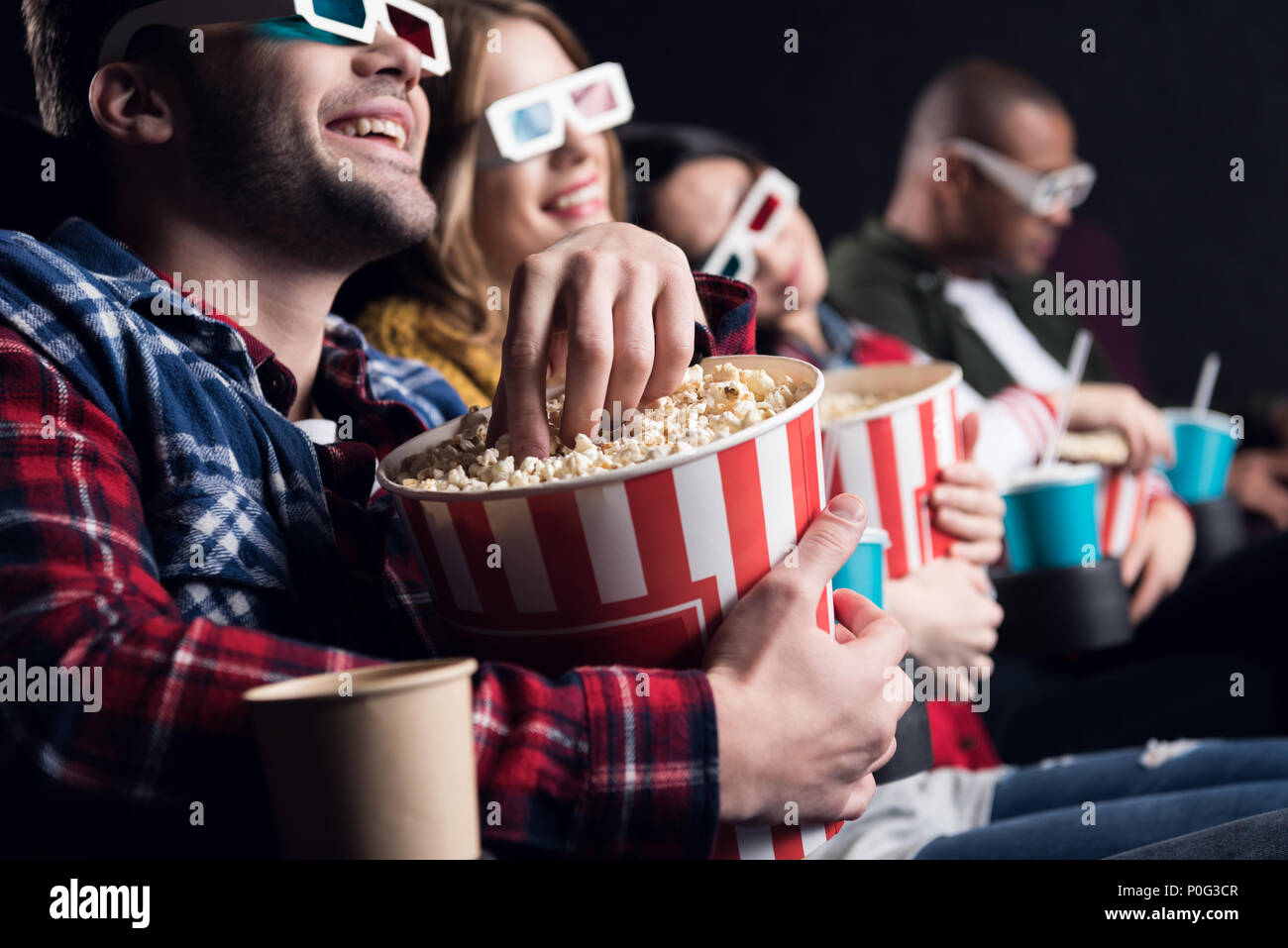 young smiling friends in 3d glasses eating popcorn and watching movie in cinema Stock Photo - Alamy