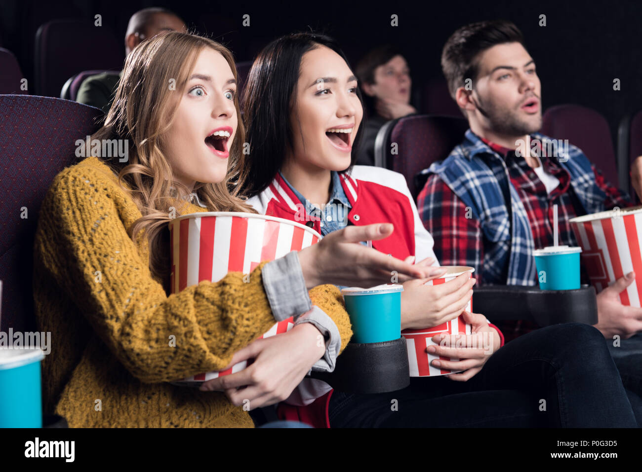 excited friends with popcorn and soda watching movie in cinema Stock ... excited friends with popcorn and soda watching movie in cinema Stock ...