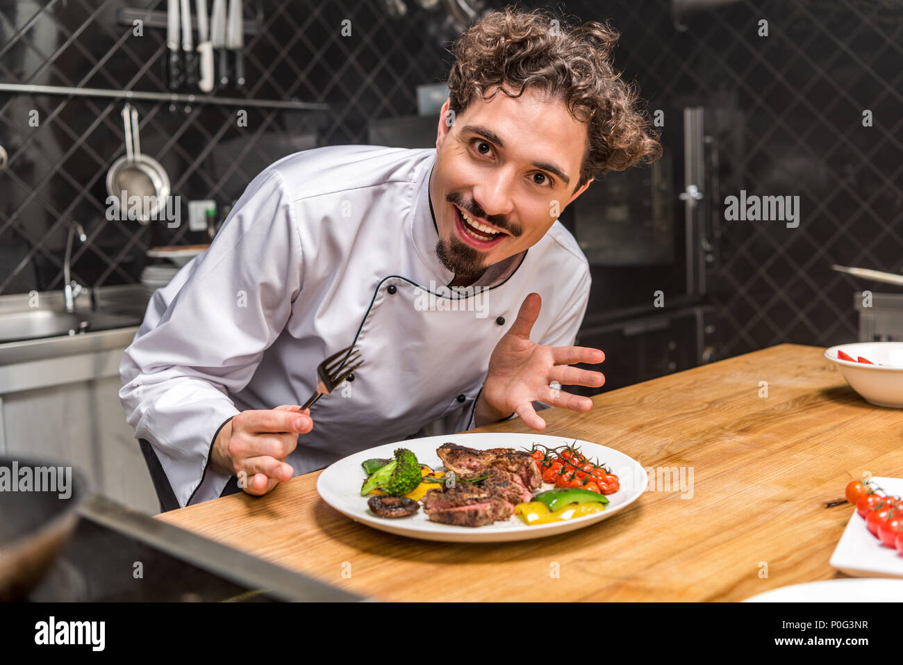 Happy chef showing dish hi-res stock photography and images - Alamy