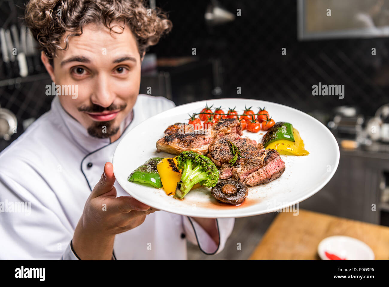 Happy chef showing dish hi-res stock photography and images - Alamy