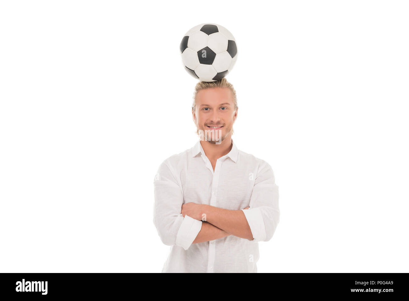 portrait of smiling man with soccer ball on head looking at camera ...