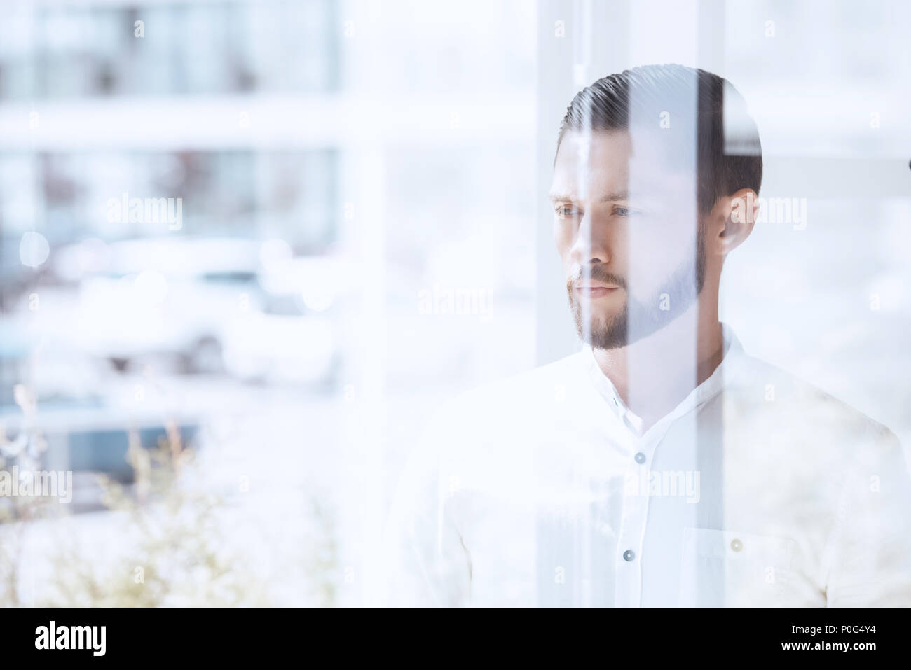 portrait of pensive caucasian businessman in shirt looking out window ...