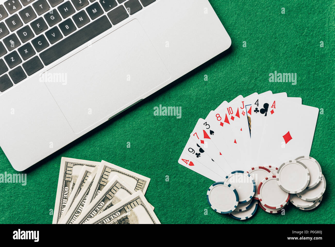 Online gambling concept with cards and money on table by laptop Stock ...