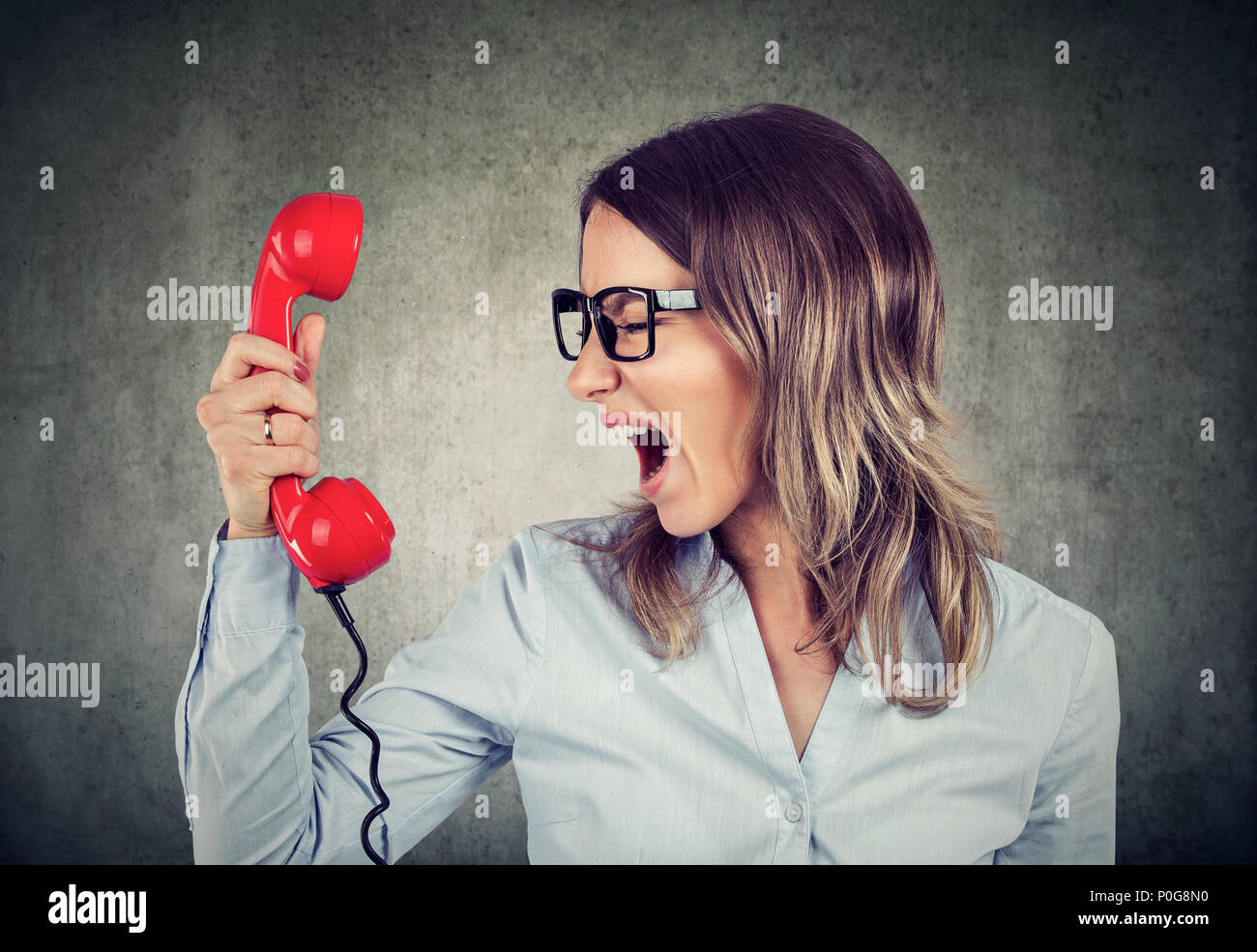 Portrait of a young angry business woman yelling at the red phone Stock ...