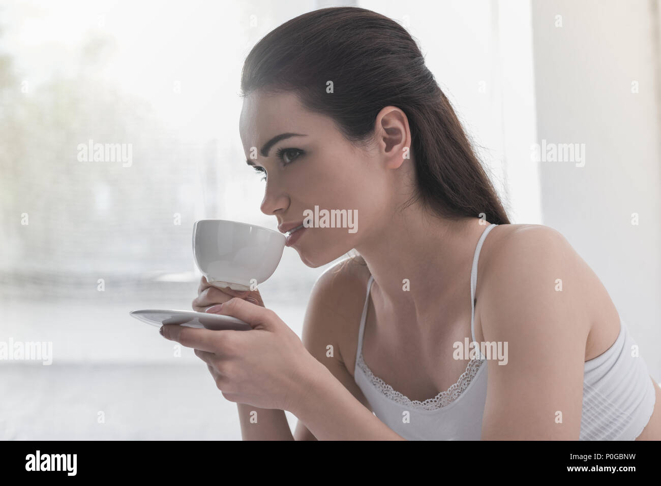 portrait of beautiful woman with cup of coffee lying on bed Stock Photo ...