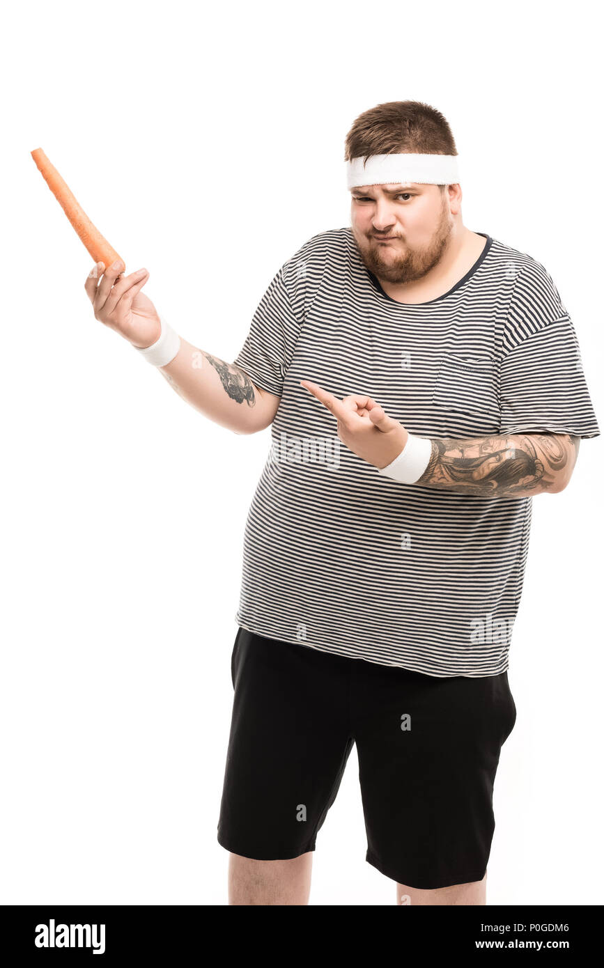 fat caucasian man pointing with finger at carrot isolated on white ...