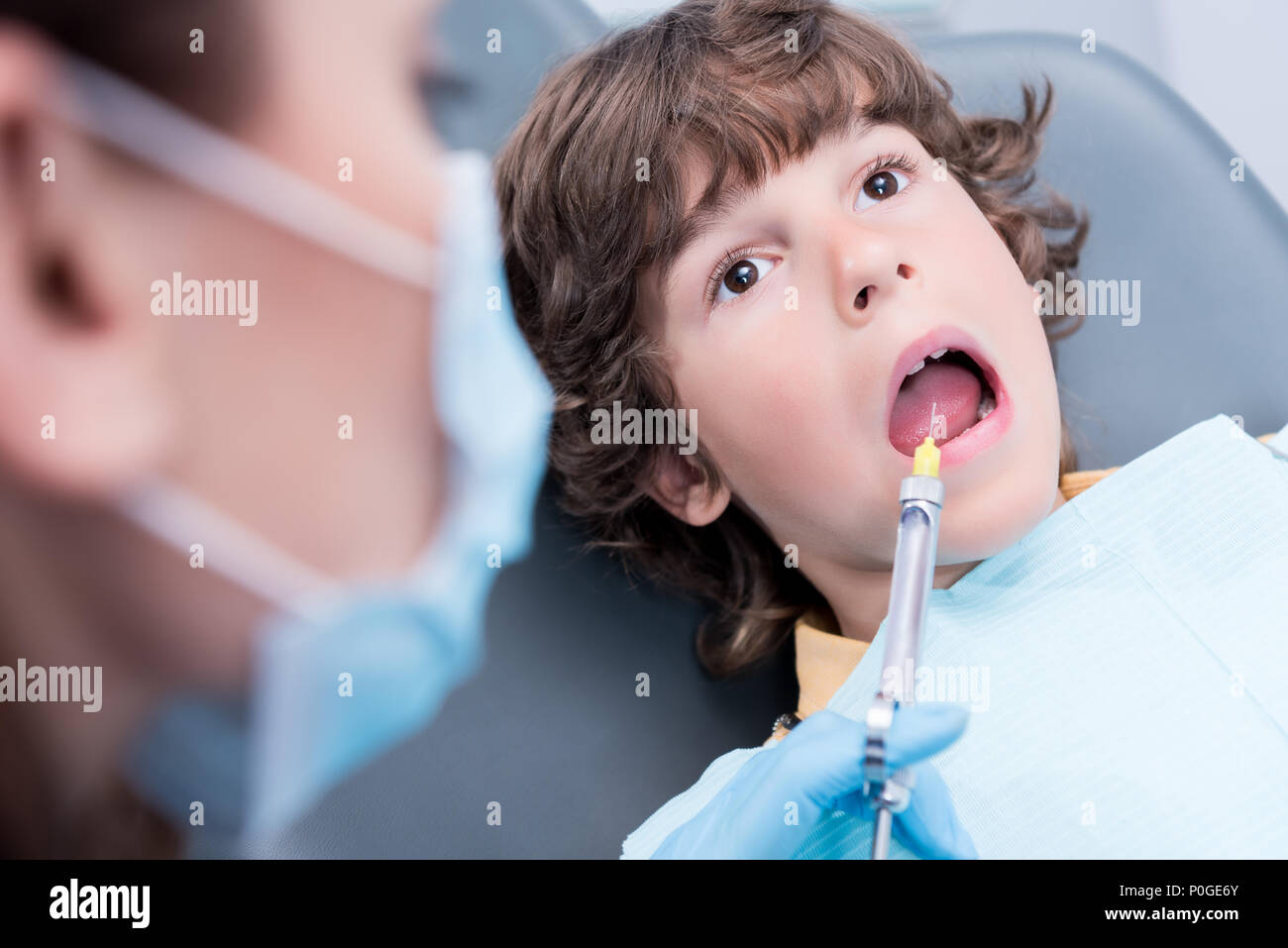 partial view of dentist giving injection on anesthesia to patient in ...