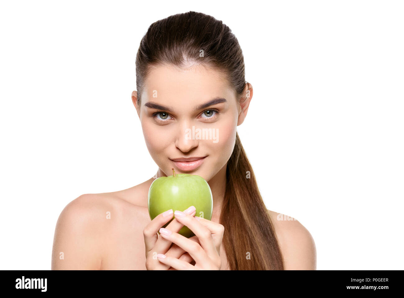 Beautiful young woman holding green apple and posing at camera isolated ...
