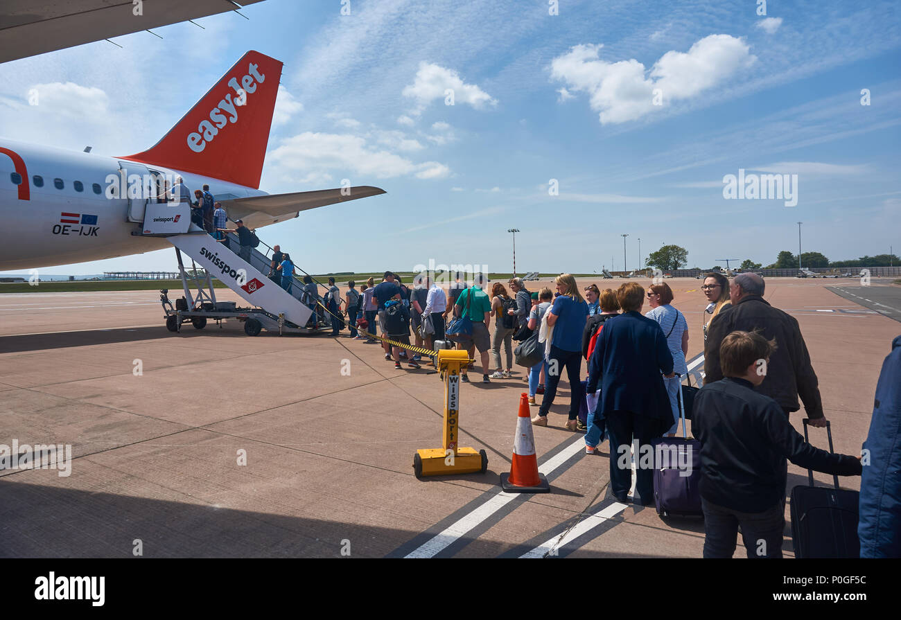 Passenger queuing and boarding the Easy jet aircraft on Bristol airport ...