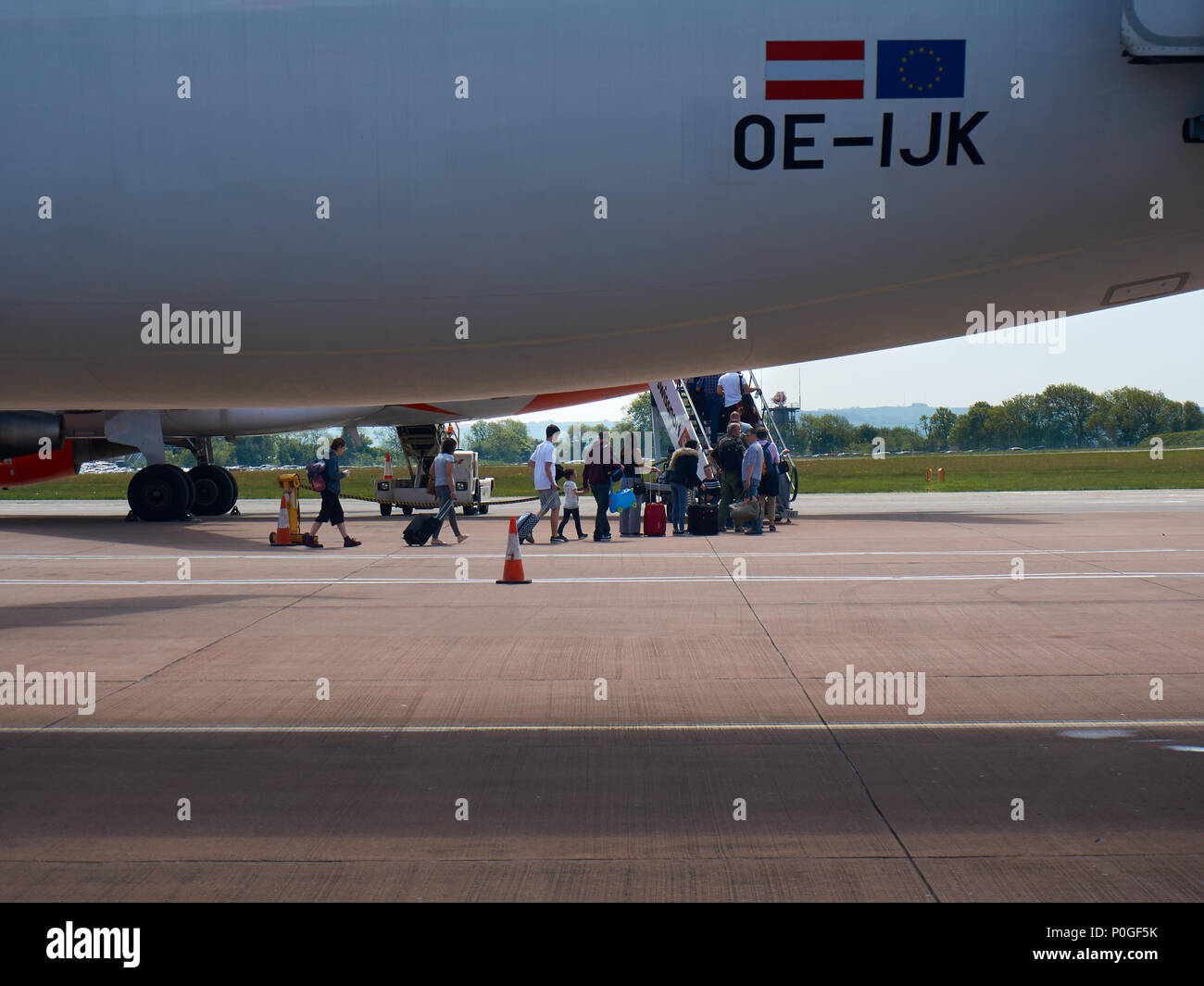 Passenger queuing and boarding the Easy jet aircraft on Bristol airport ...