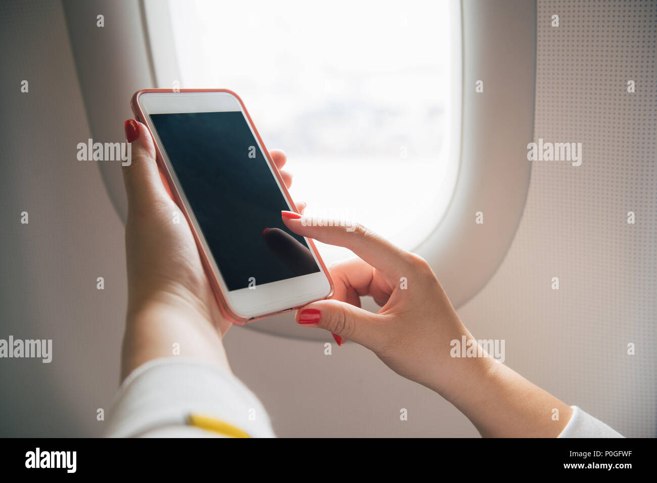 holding digital mobile phone at airplane Stock Photo - Alamy
