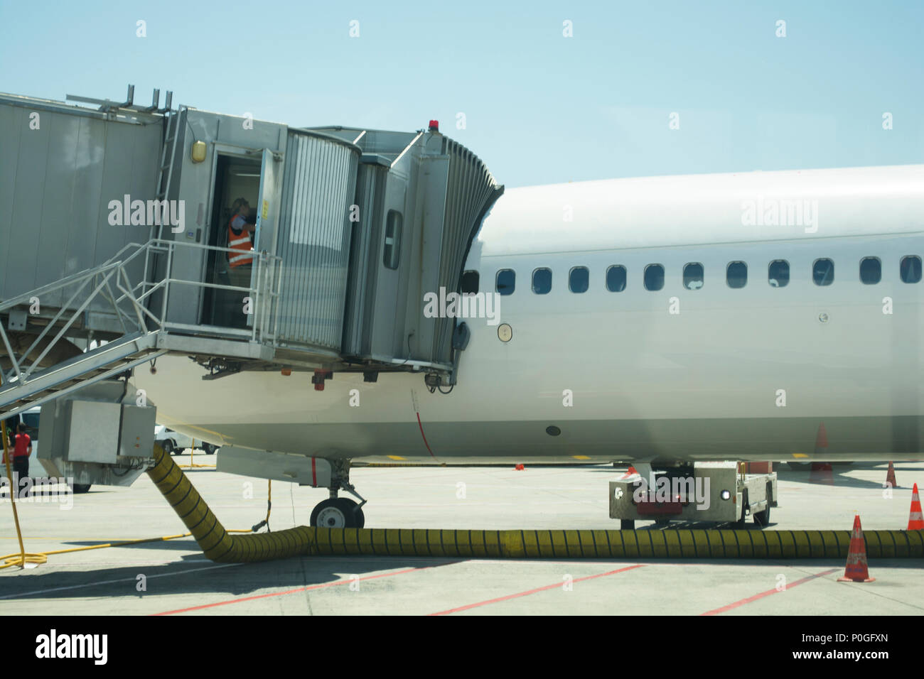 Modern passenger airplane parked to terminal building gate at airside ...