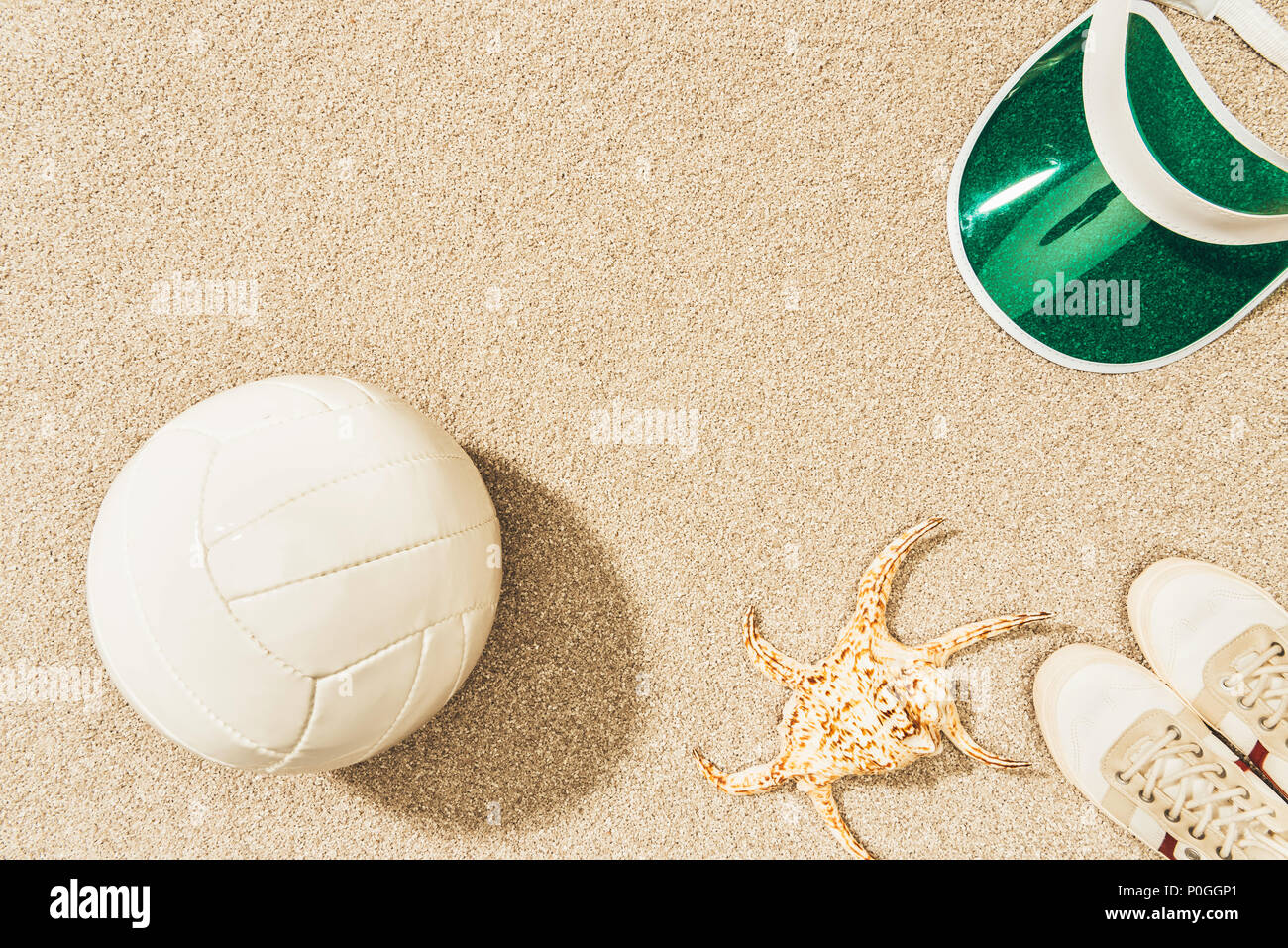 flat lay with volleyball ball, cap, sneakers and sea star on sand Stock ...