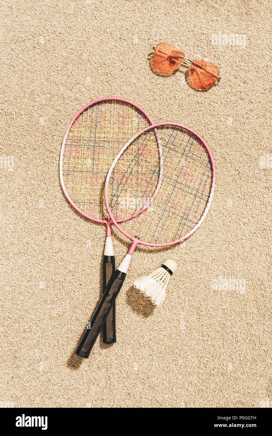 top view of arranged badminton equipment and sunglasses on sand Stock ...