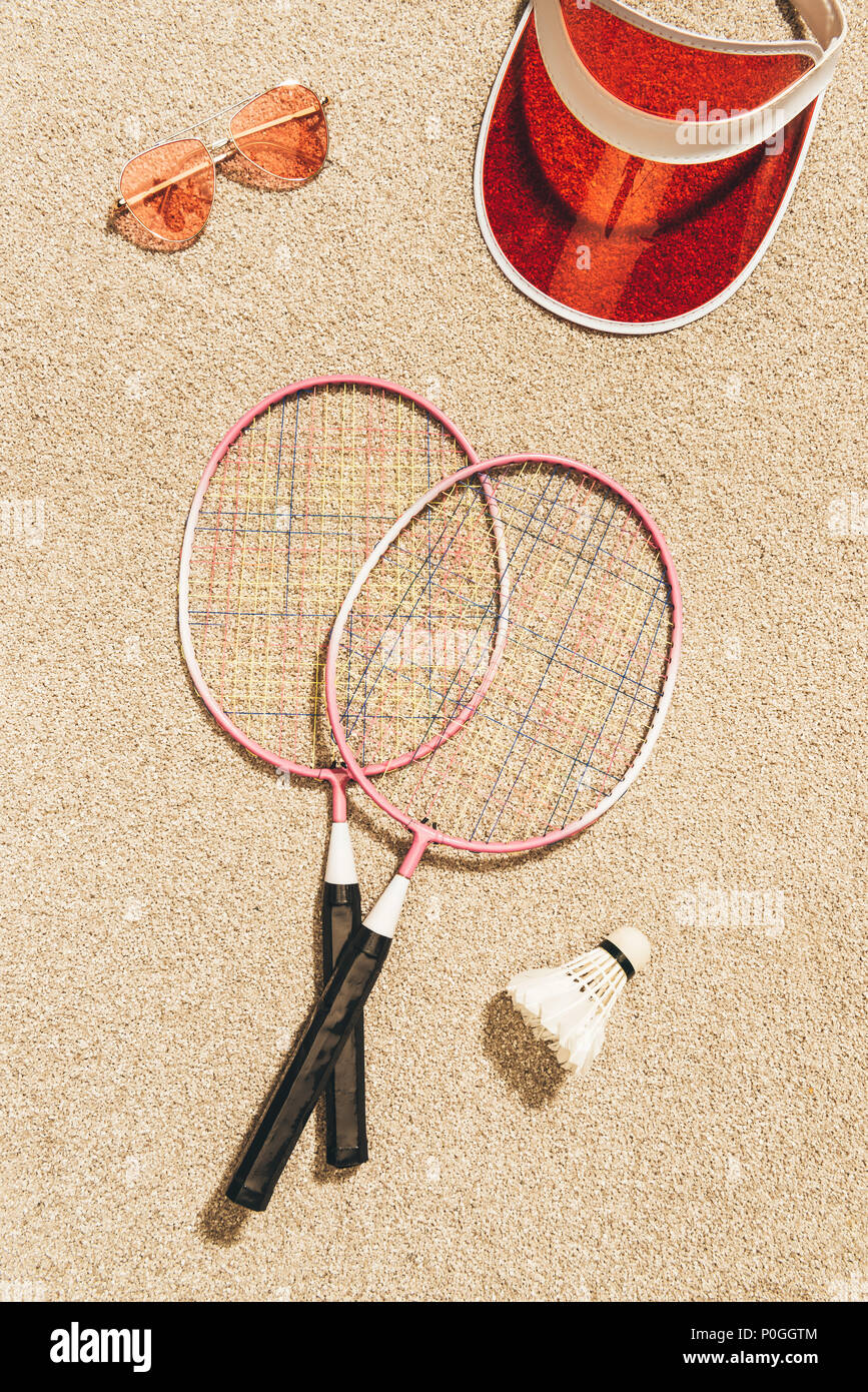 top view of badminton equipment, sunglasses and cap on sand Stock Photo ...