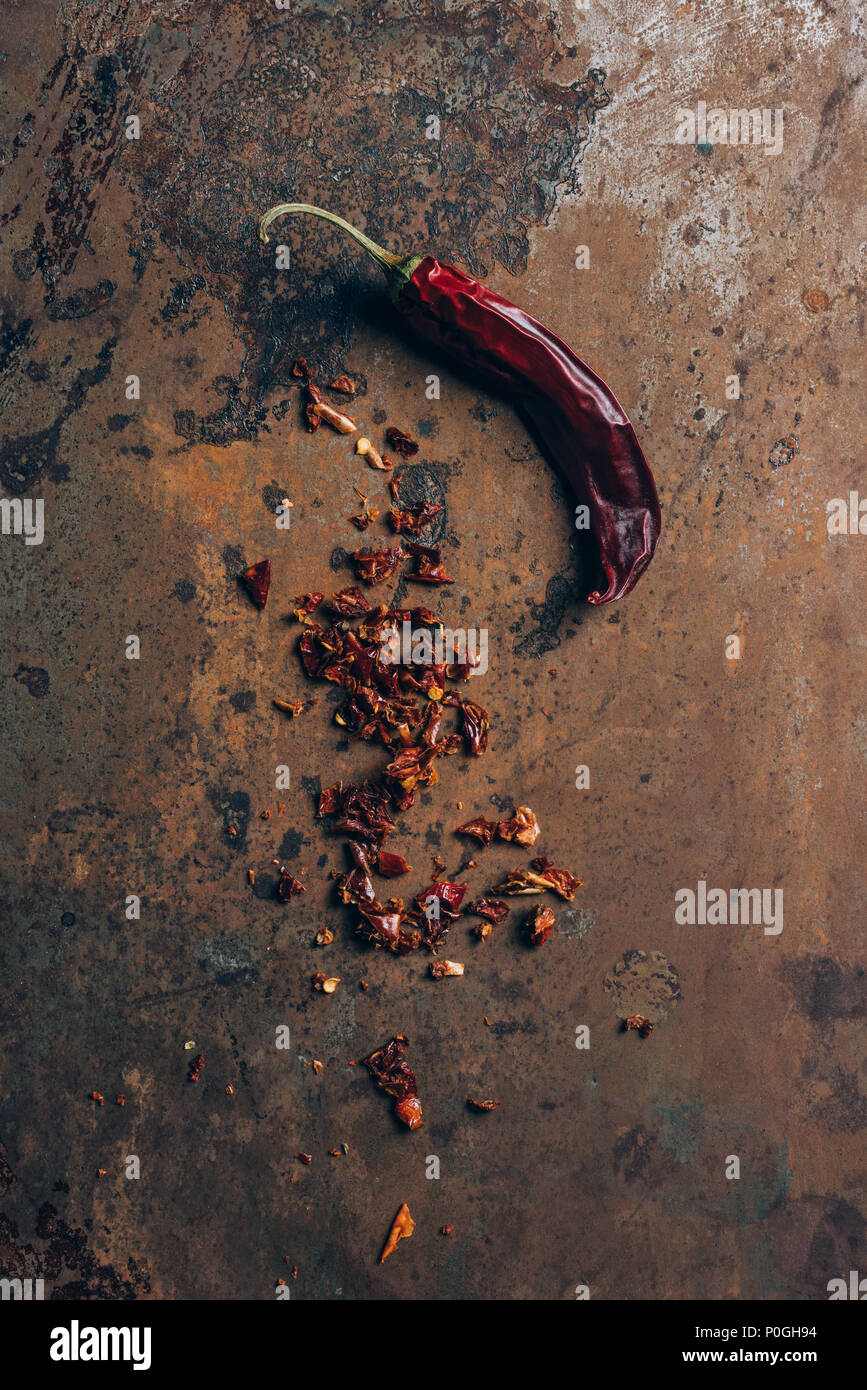 top view of chilli flakes and chili pepper on grungy table Stock Photo ...