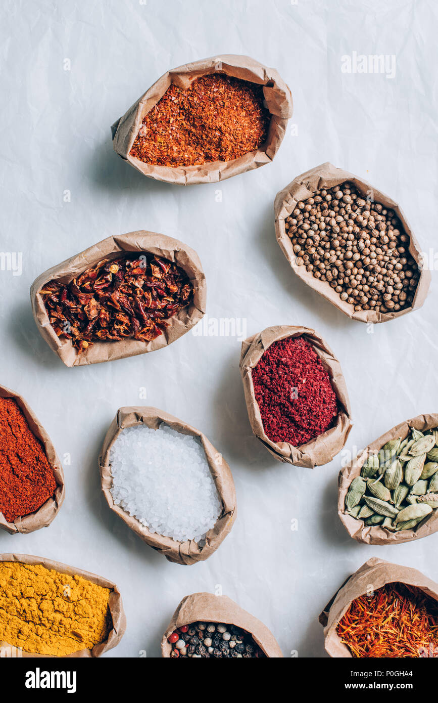 top view of colorful indian spices in paper bags on white table Stock ...