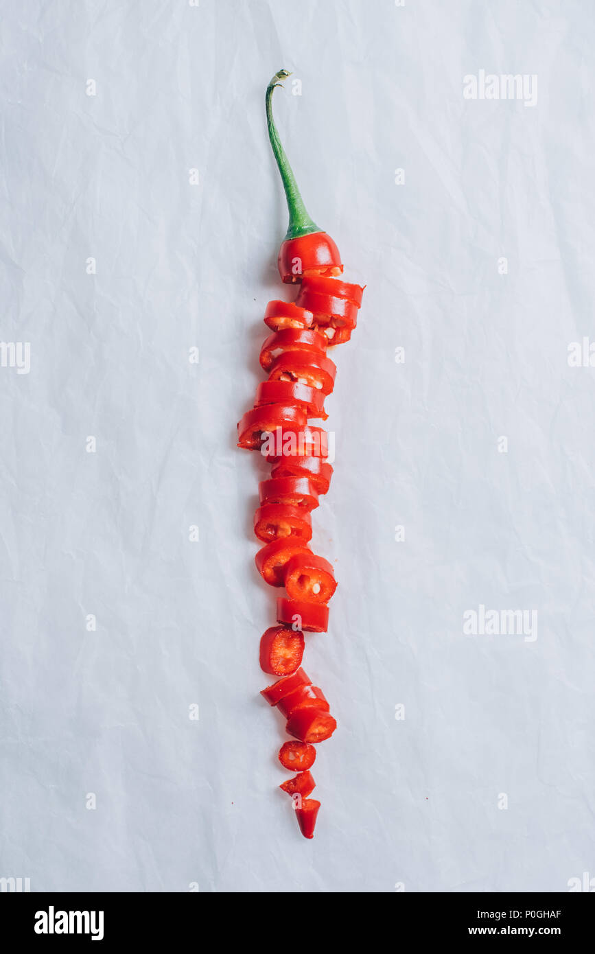 top view of cut red chili pepper on white table Stock Photo - Alamy