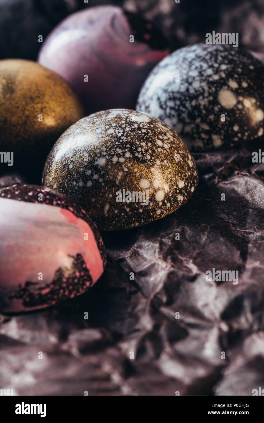 closeup view of pile of different chocolate candies on crumpled wrapper ...