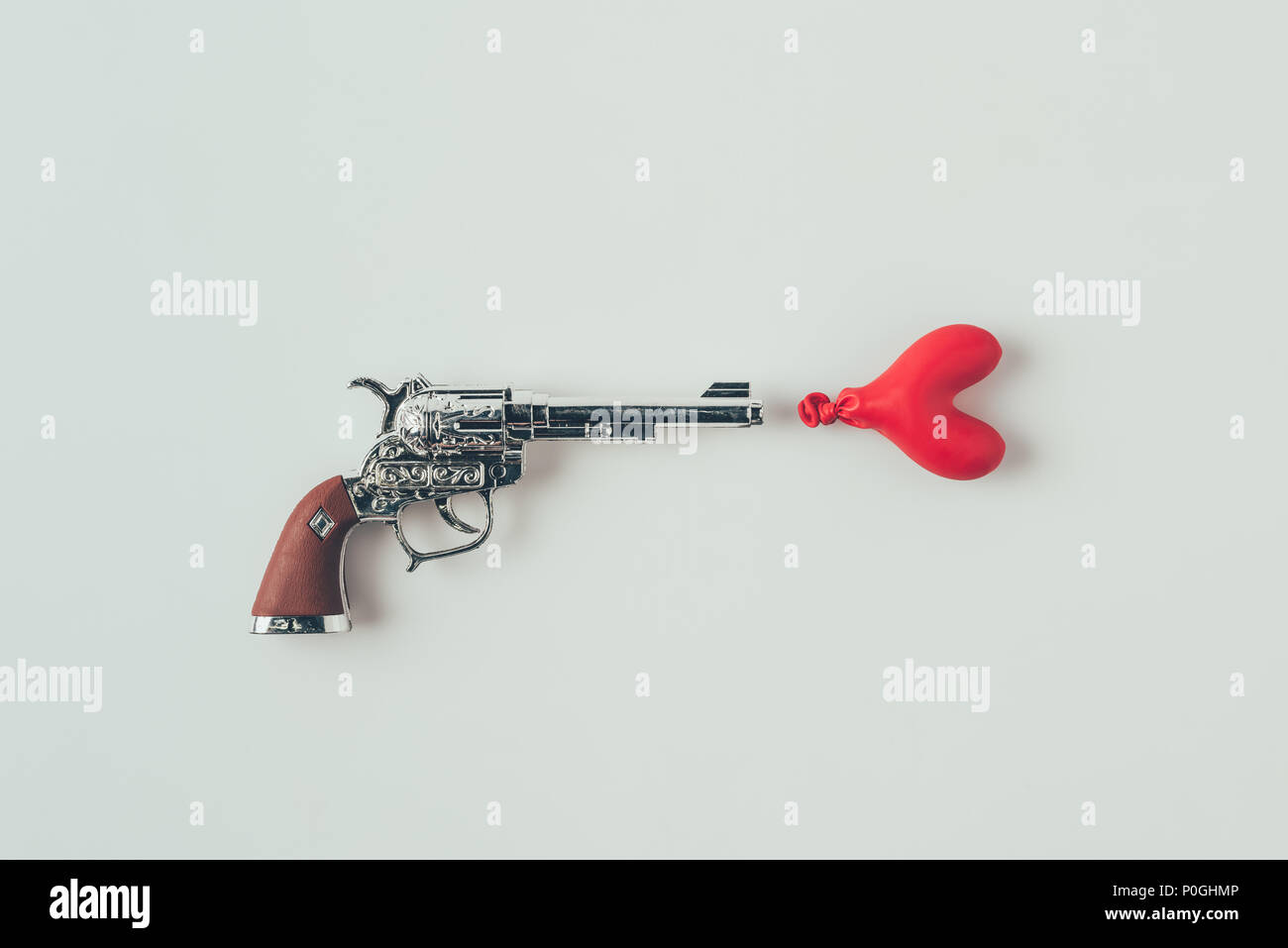top view of gun aiming at heart shaped balloon isolated on white Stock ...