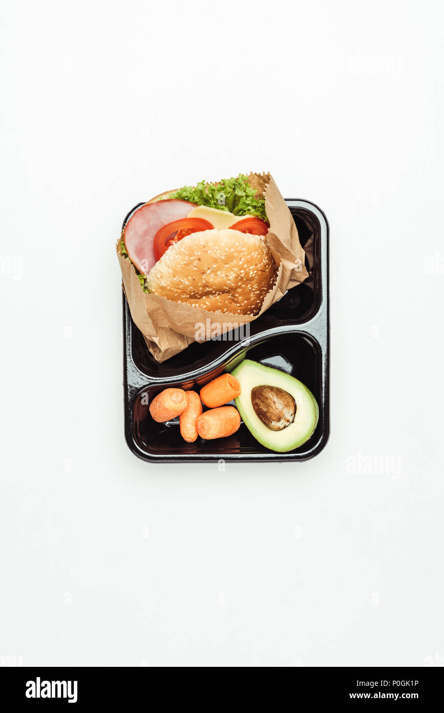 top view of lunch box with burger and vegetables isolated on white ...