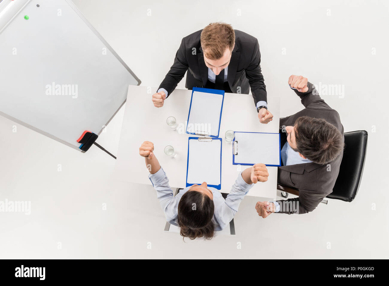 overhead view of excited business people celebrating triumph during ...