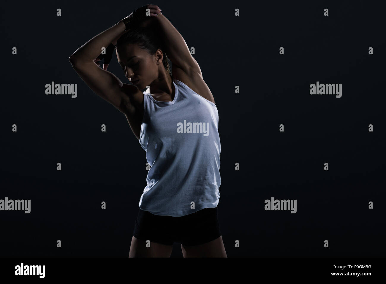 beautiful young female bodybuilder stretching, isolated on black Stock ...