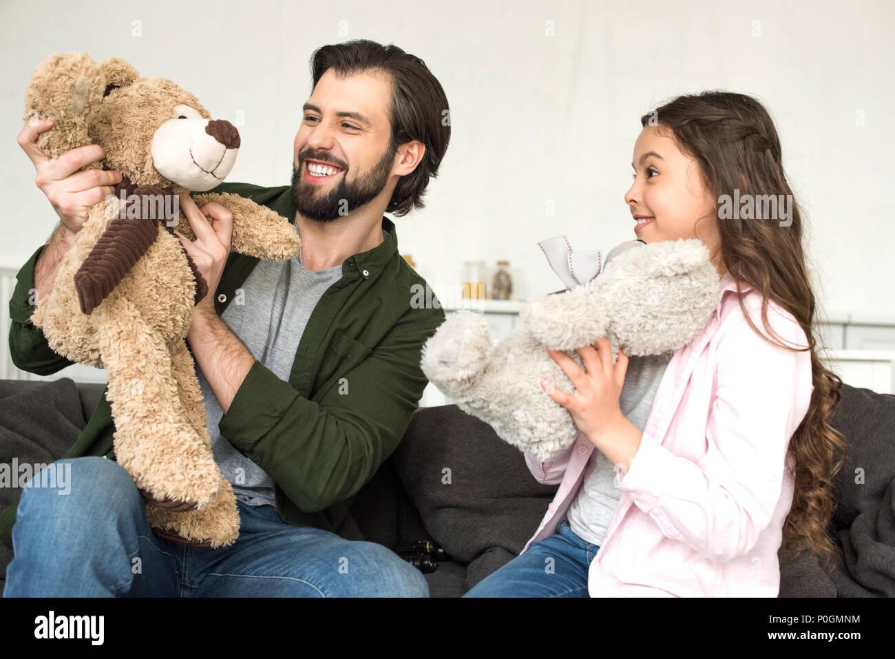 happy father and daughter playing with teddy bears at home Stock Photo ...