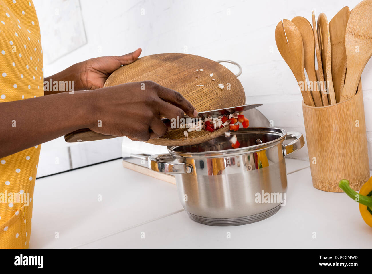 partial view of african american woman putting ingredientes into ...