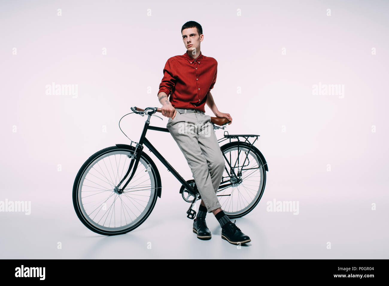 Young man leaning on his bicycle on white background Stock Photo - Alamy