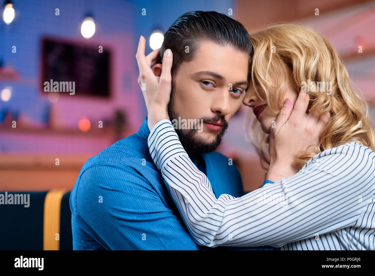 beautiful blonde woman and handsome young man flirting in bar Stock ...
