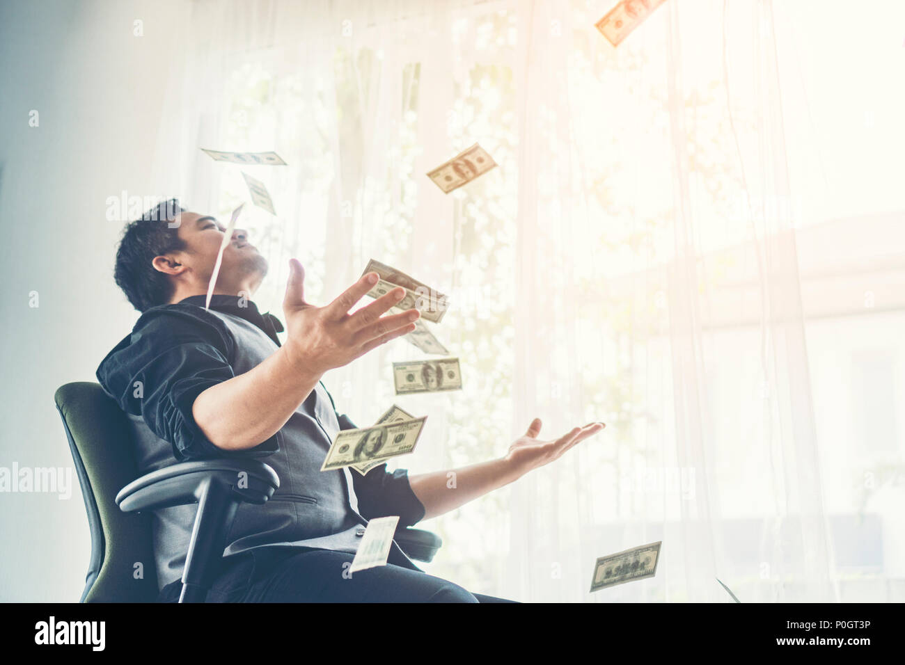 happy business man earned dollar bills us money under a money rain ...